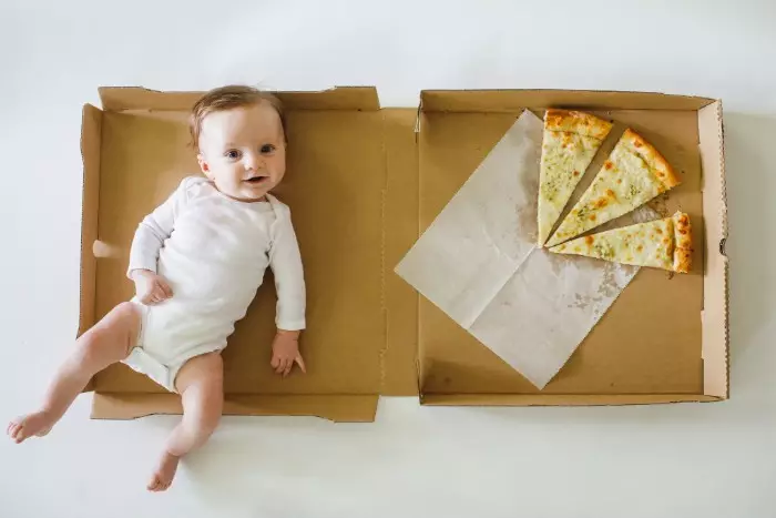 Веселая мама, которая фотографирует «ежемесячную веху» сына, используя пироги с пиццей, является родительской целью 1807_3